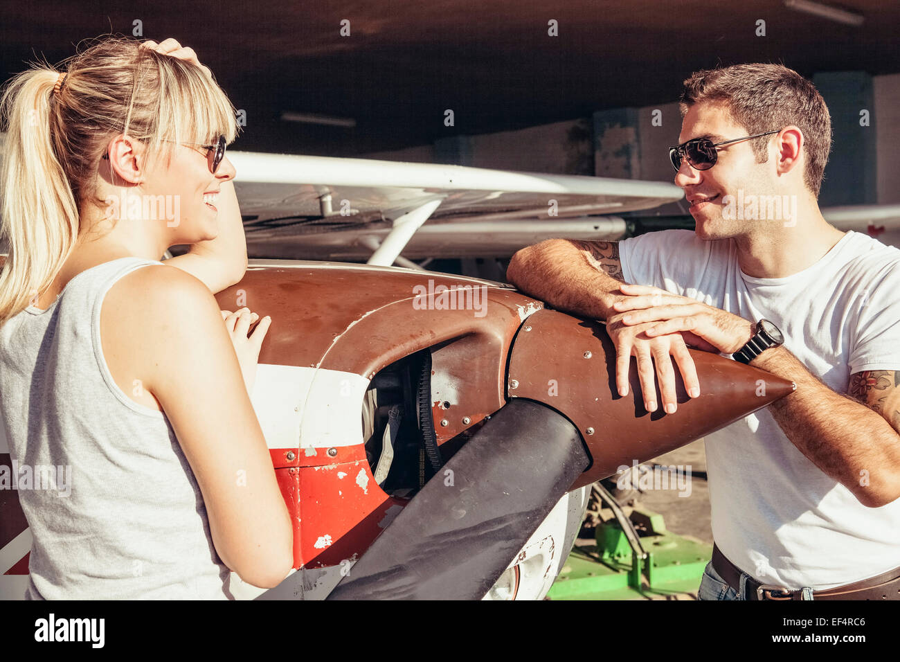 Young couple preparing for start in propeller airplane Stock Photo - Alamy