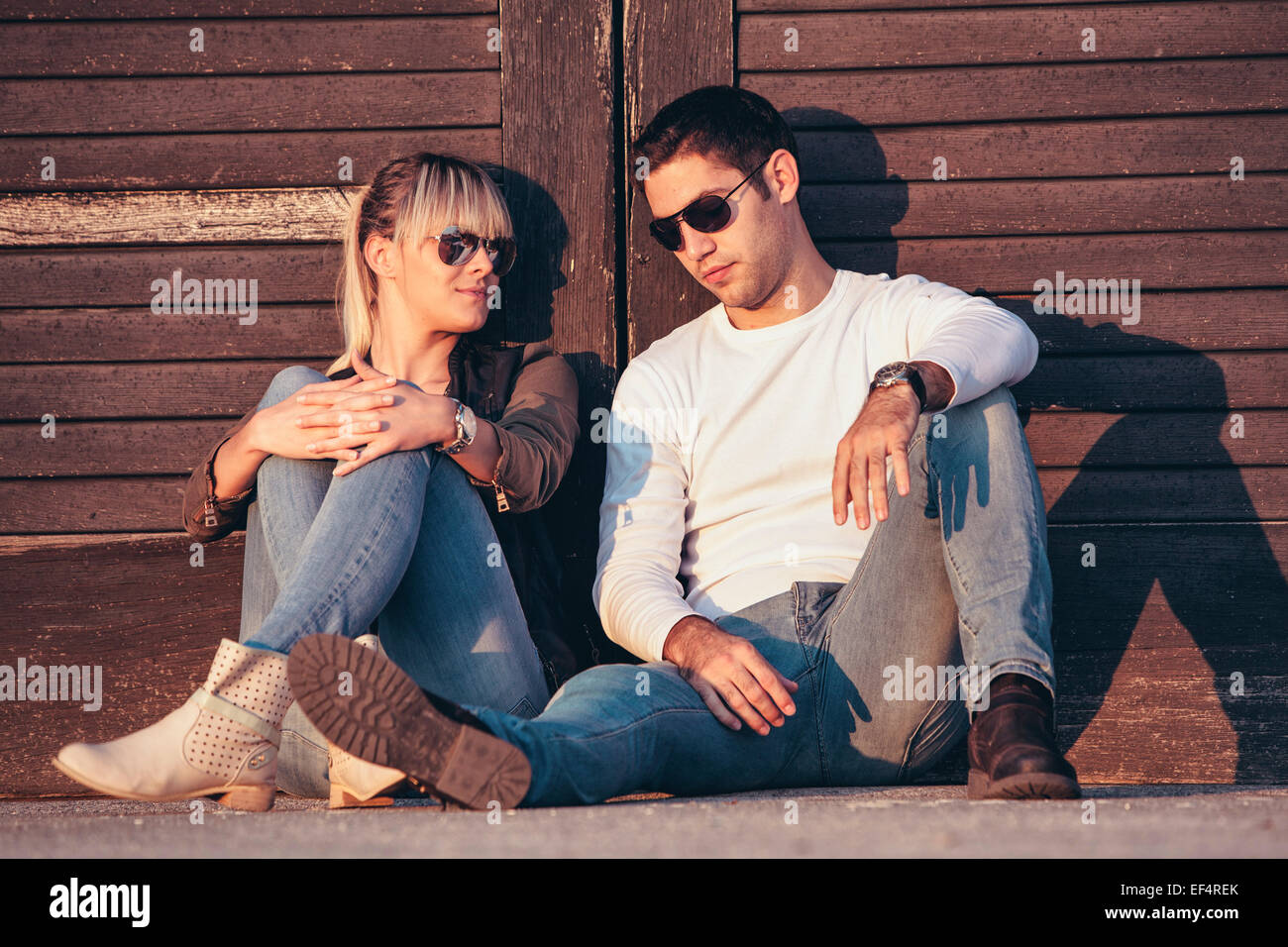Two women sitting side by side outdoors hi-res stock photography and ...