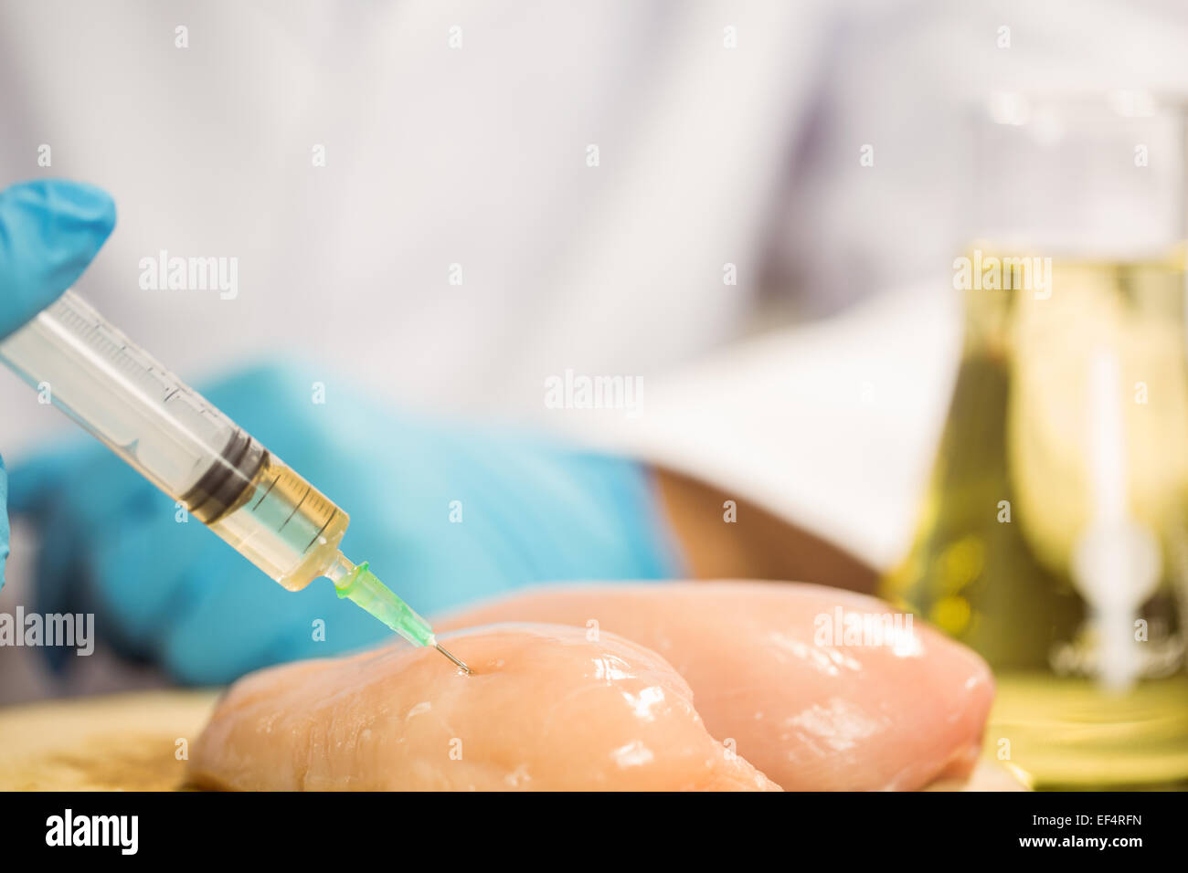 Food scientist injecting raw chicken Stock Photo - Alamy
