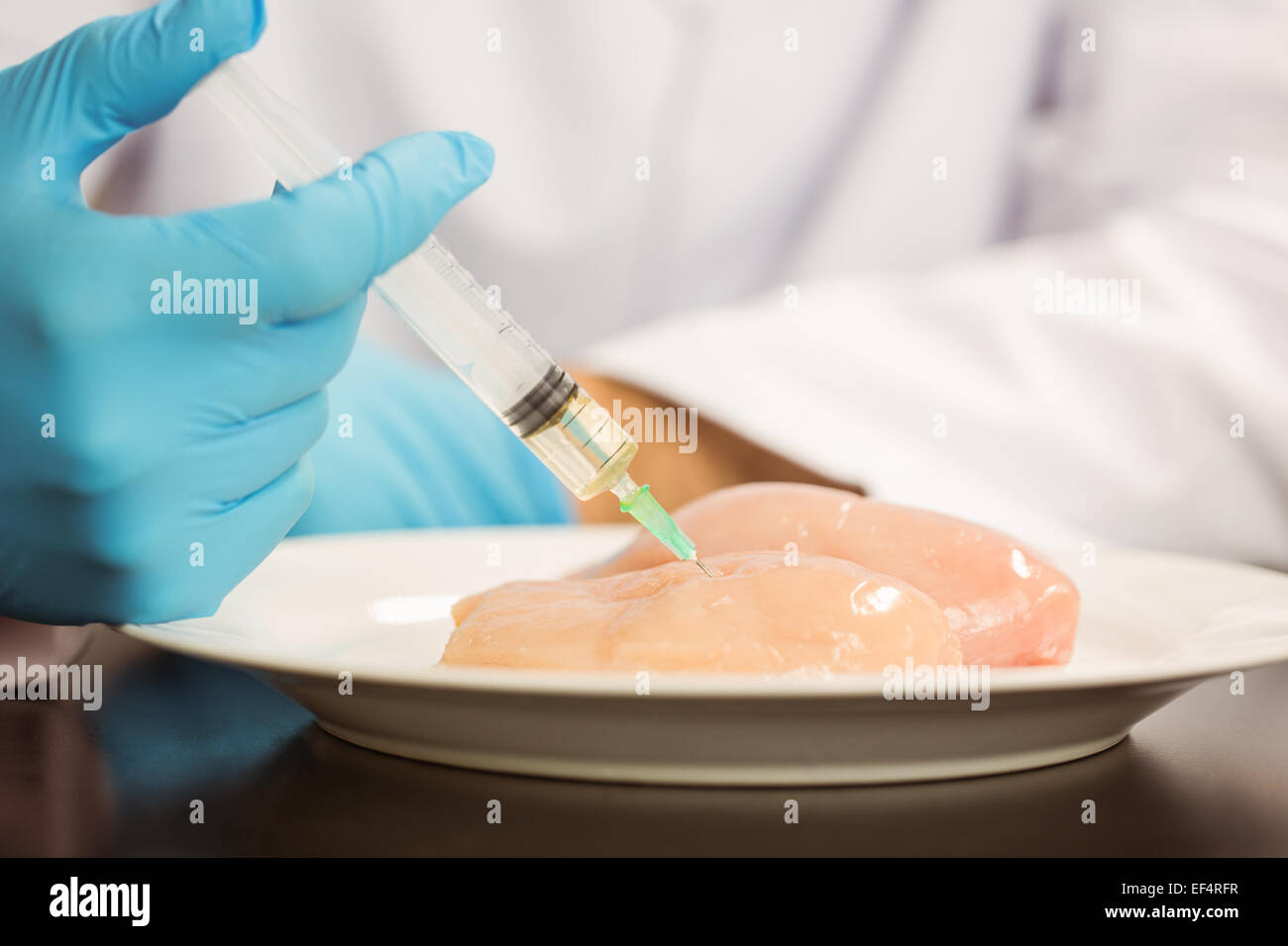 Food scientist injecting raw chicken Stock Photo - Alamy