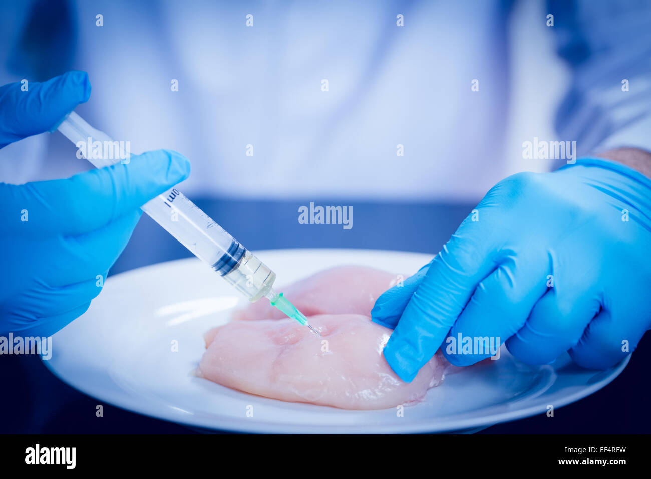 Food scientist injecting raw chicken Stock Photo - Alamy