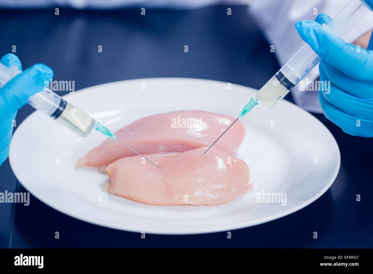 Food scientist injecting raw chicken Stock Photo - Alamy