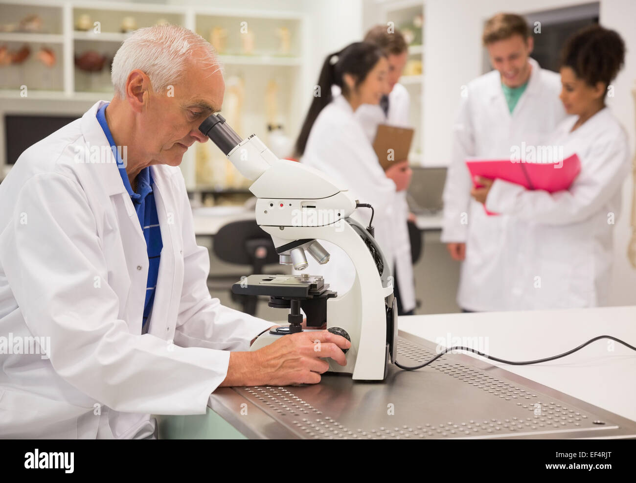 Medical professor working with microscope Stock Photo - Alamy