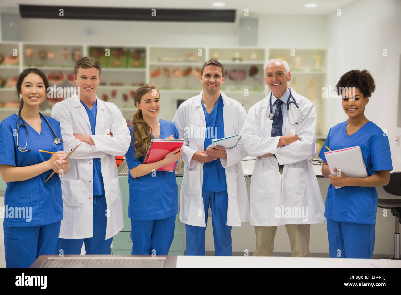 Medical professor smiling at camera with students Stock Photo - Alamy