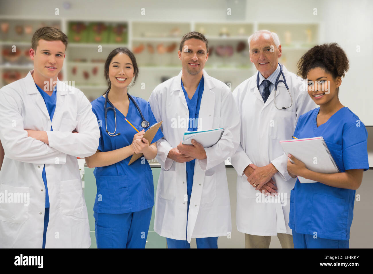 Medical professor smiling at camera with students Stock Photo - Alamy