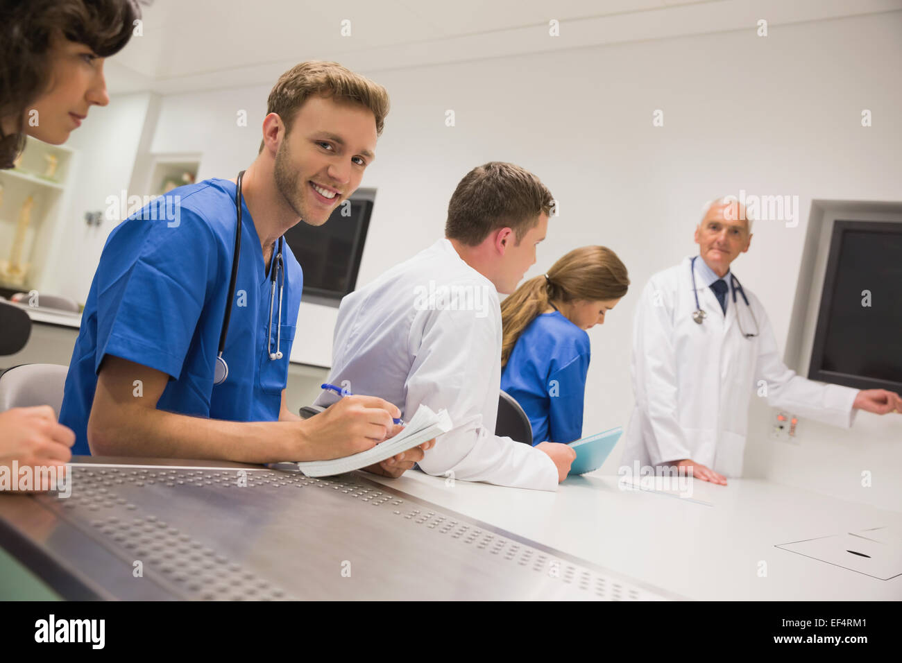 Medical student smiling at the camera during class Stock Photo - Alamy