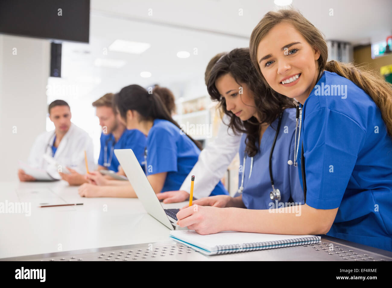 Medical student smiling at the camera during class Stock Photo - Alamy