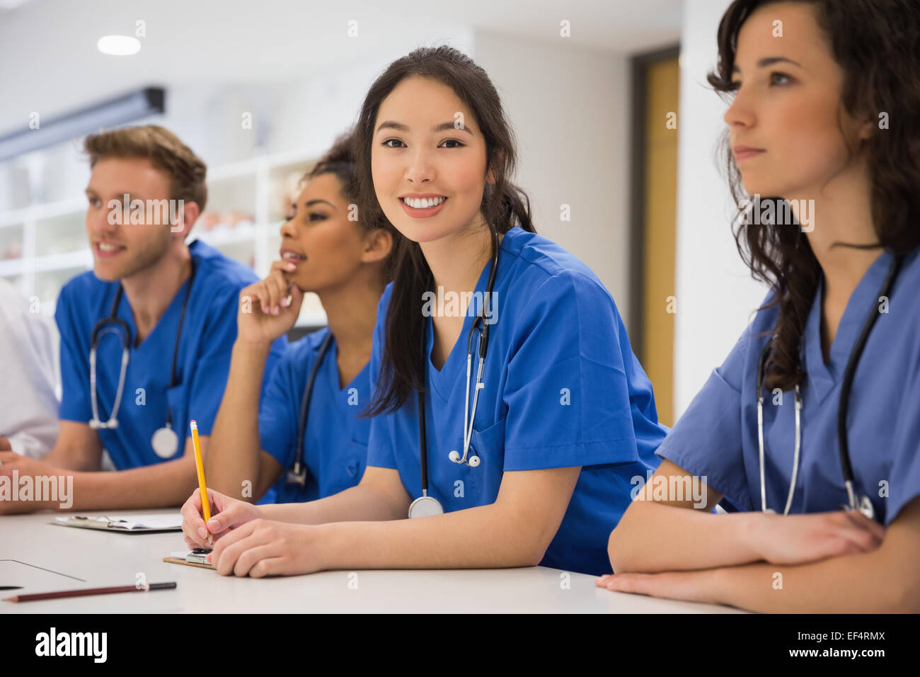 Medical student smiling at the camera during class Stock Photo - Alamy