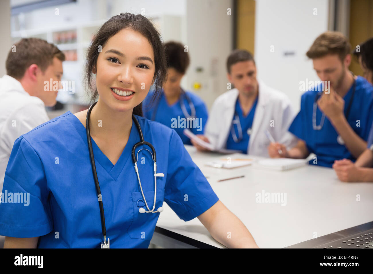 Medical student smiling at the camera during class Stock Photo - Alamy