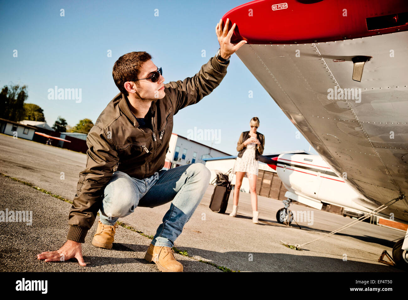 Pilot checking wing of propeller airplane Stock Photo - Alamy