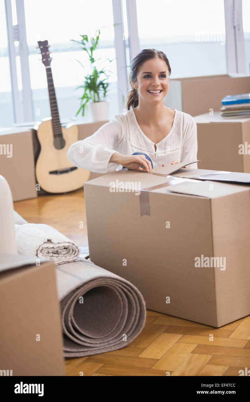 Smiling woman unpacking cardboard boxes Stock Photo - Alamy