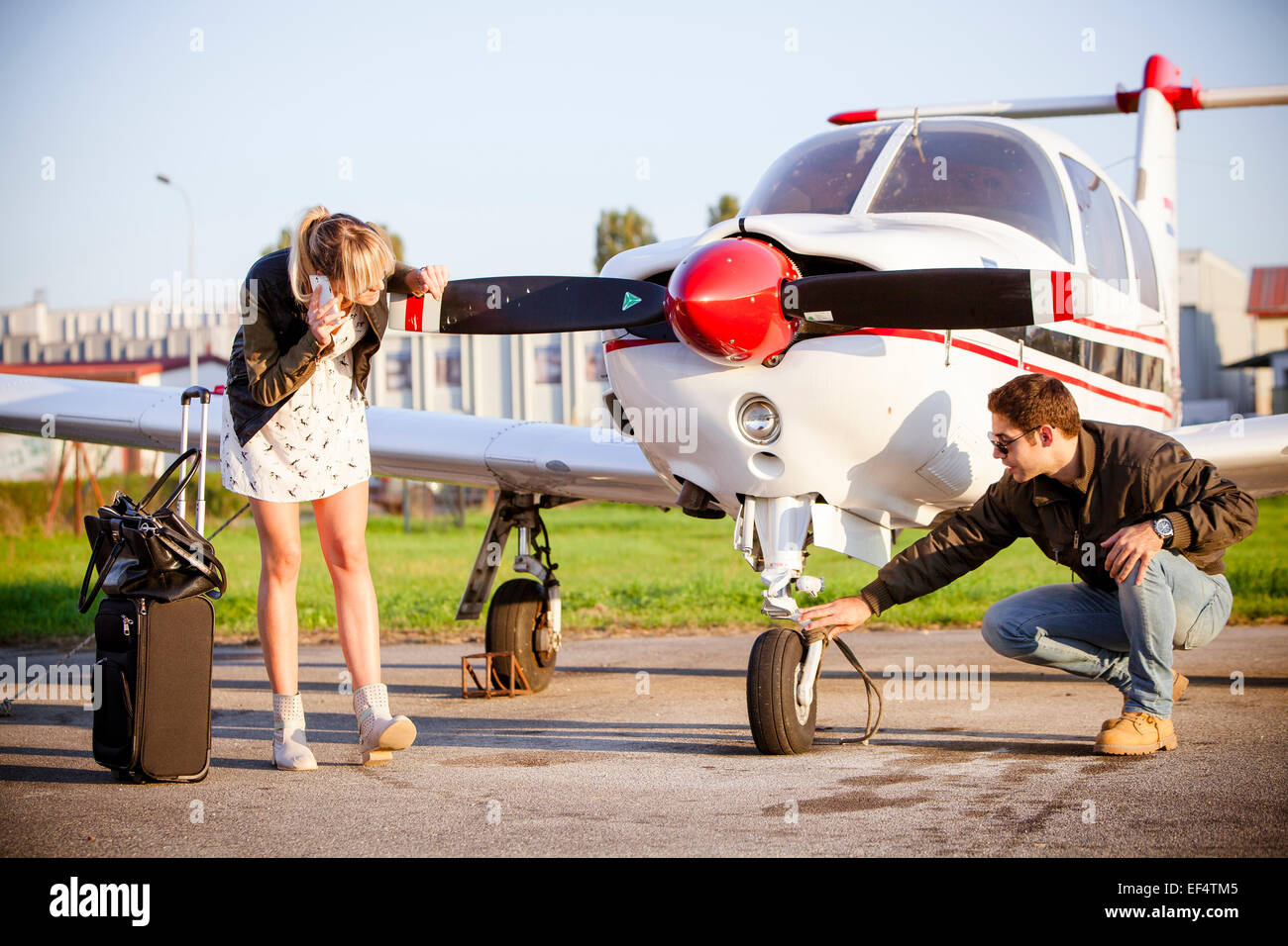 Young couple checking propeller airplane Stock Photo - Alamy