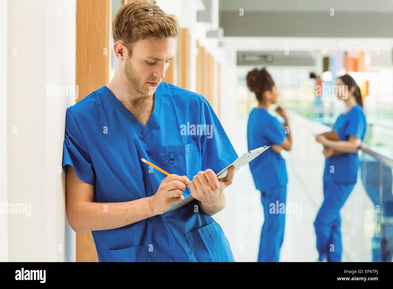 Medical student taking notes in hallway Stock Photo - Alamy