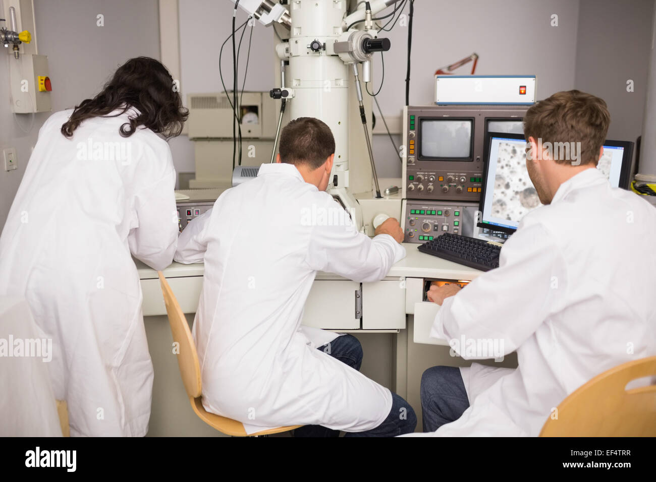 Biochemistry students using large microscope and computer Stock Photo ...