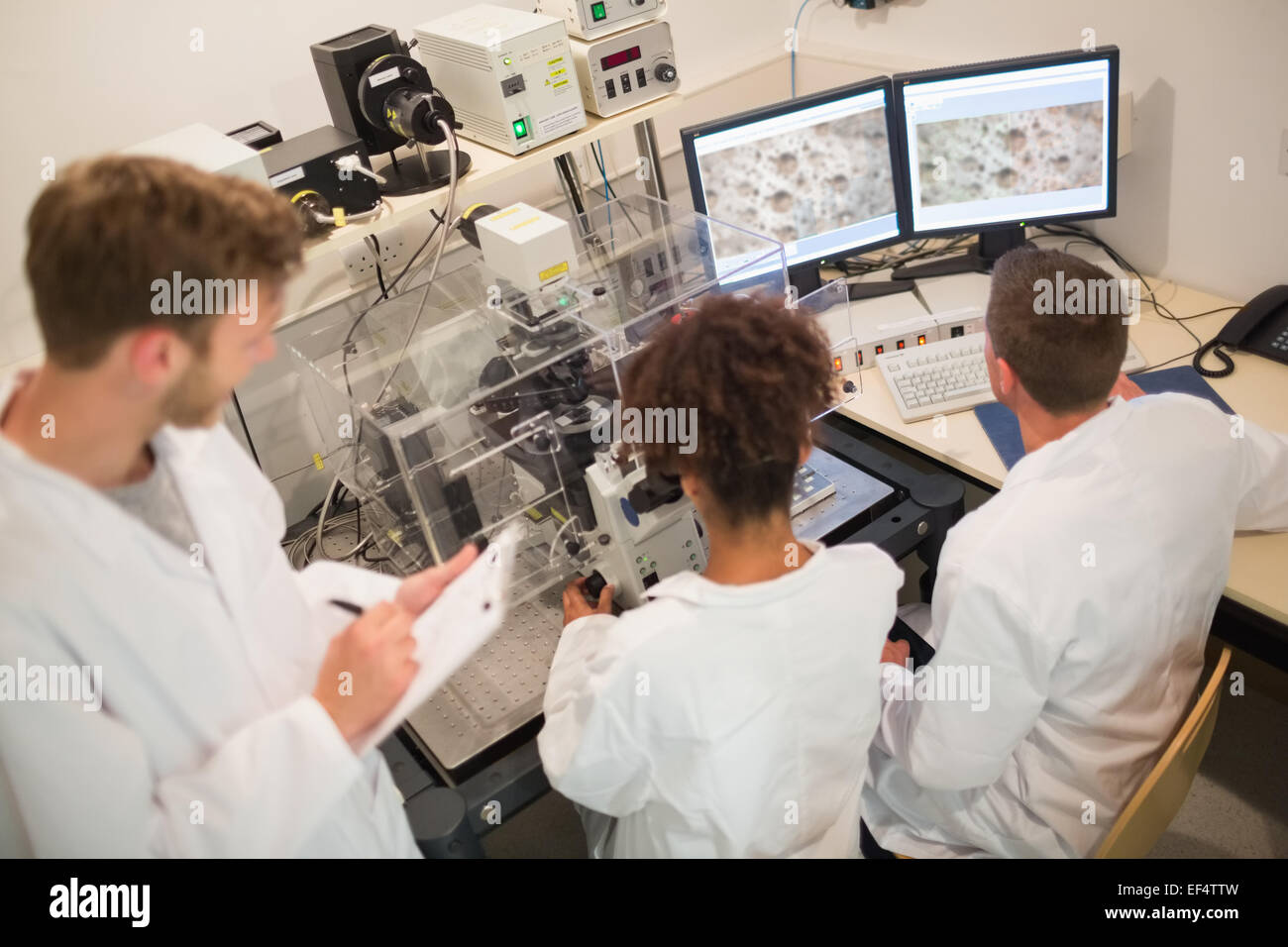 Biochemistry students using large microscope and computer Stock Photo ...