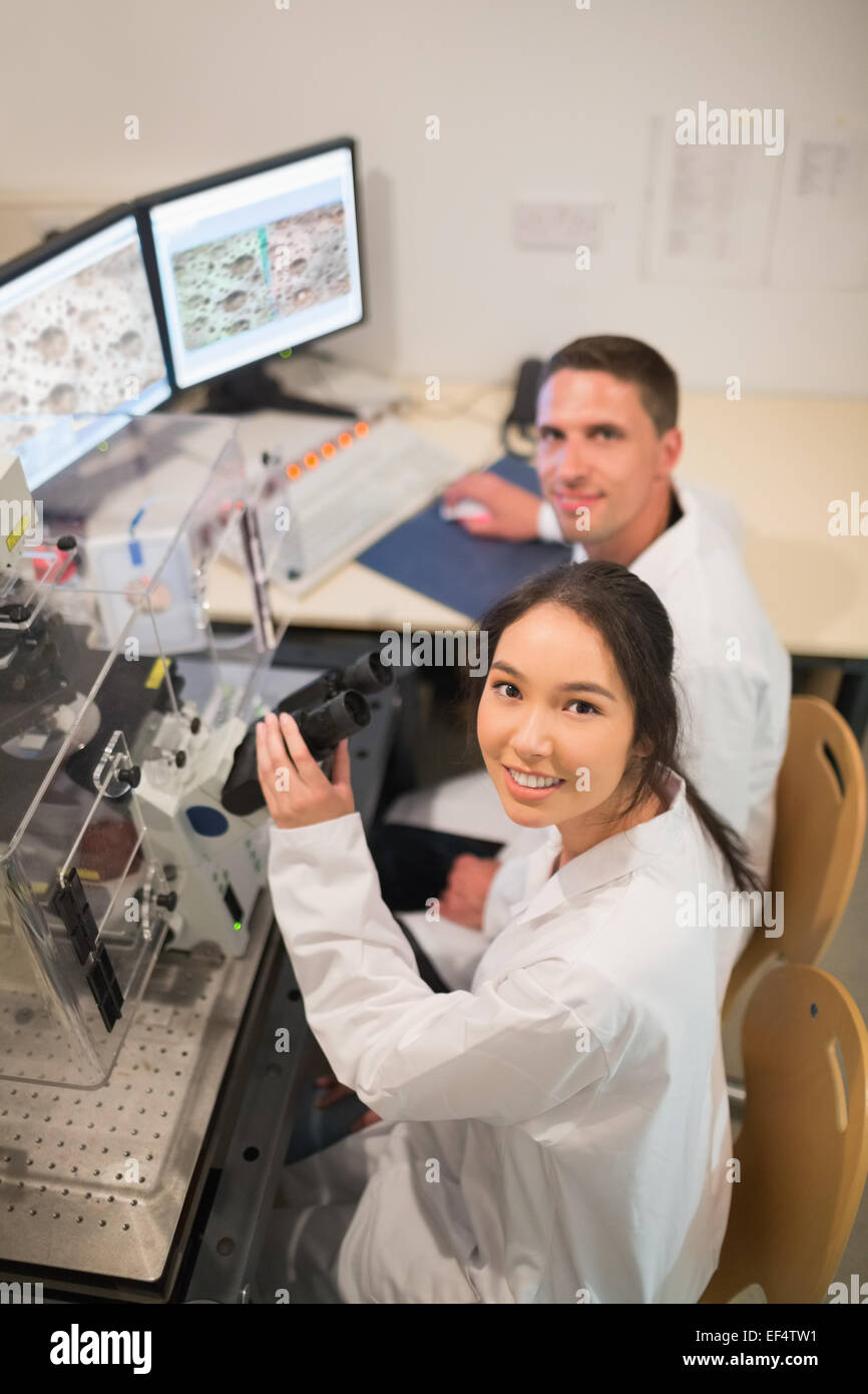 Biochemistry students using large microscope and computer Stock Photo ...