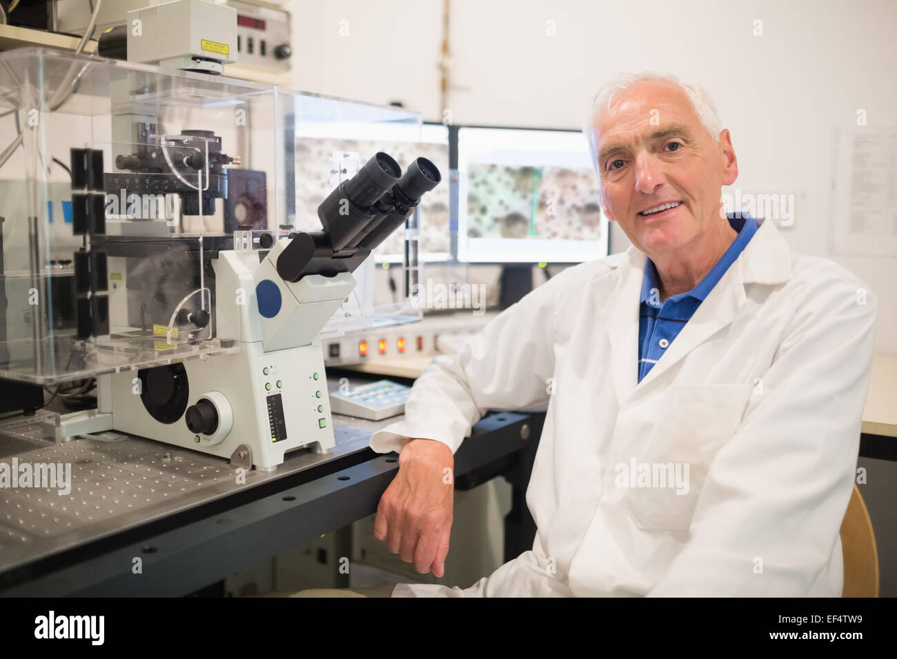 Biochemist using large microscope and computer Stock Photo - Alamy