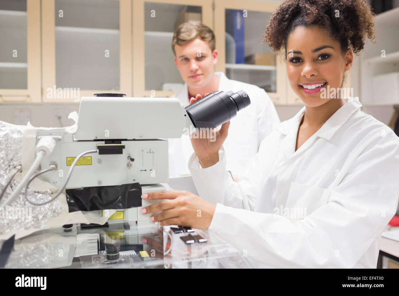 Pretty science student using microscope Stock Photo - Alamy