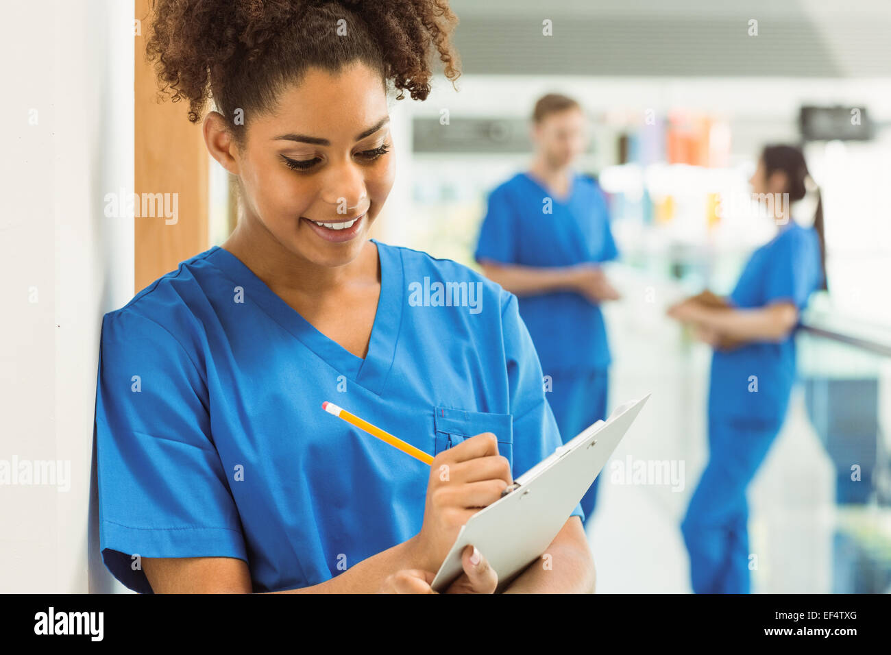 Medical student taking notes in hallway Stock Photo - Alamy