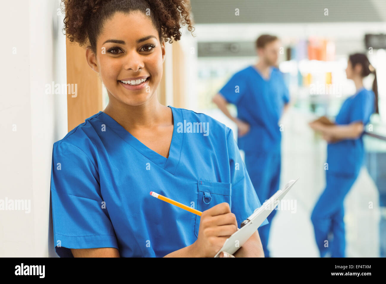 Medical student taking notes in hallway Stock Photo - Alamy