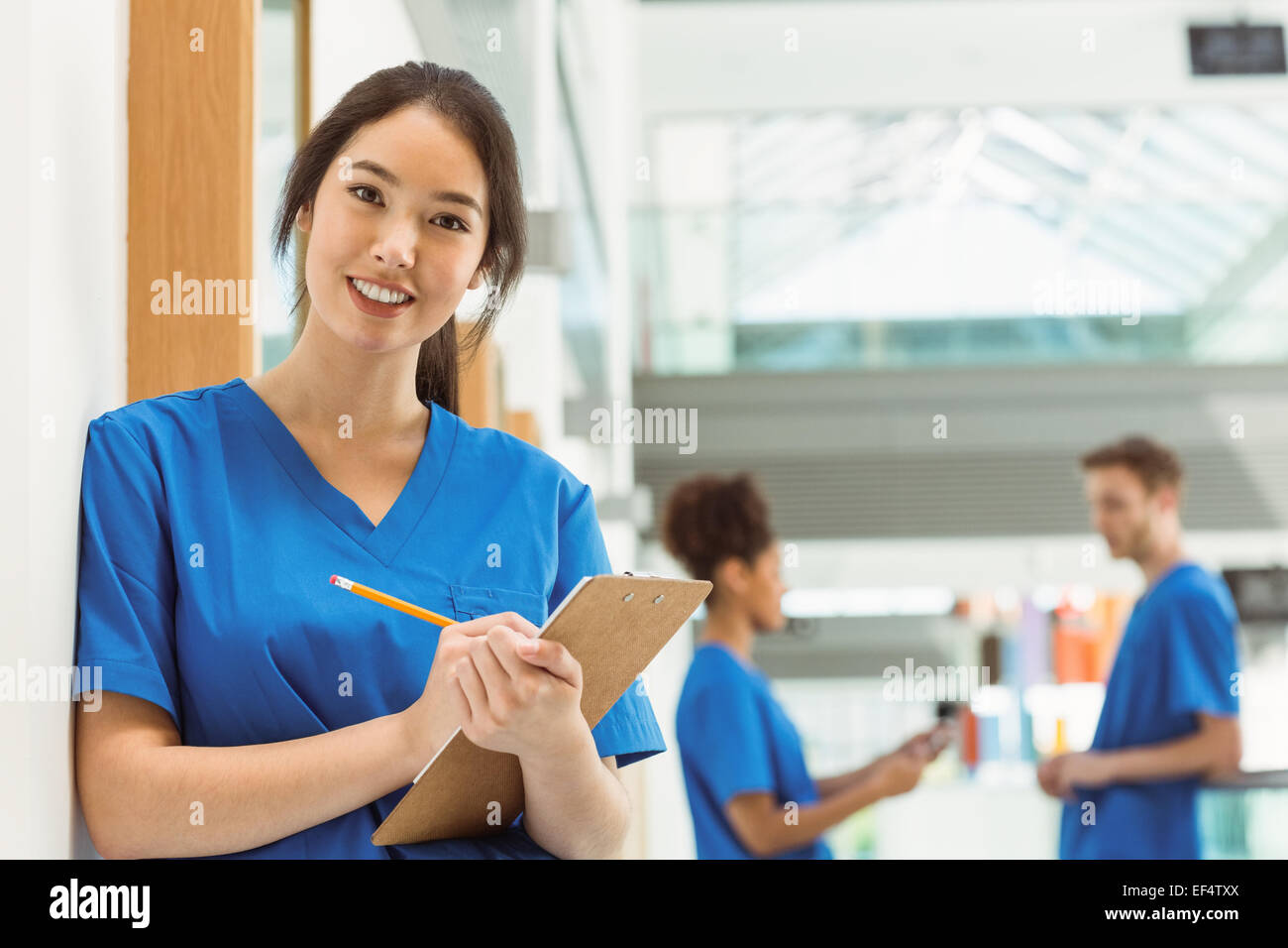 Medical student taking notes in hallway Stock Photo - Alamy