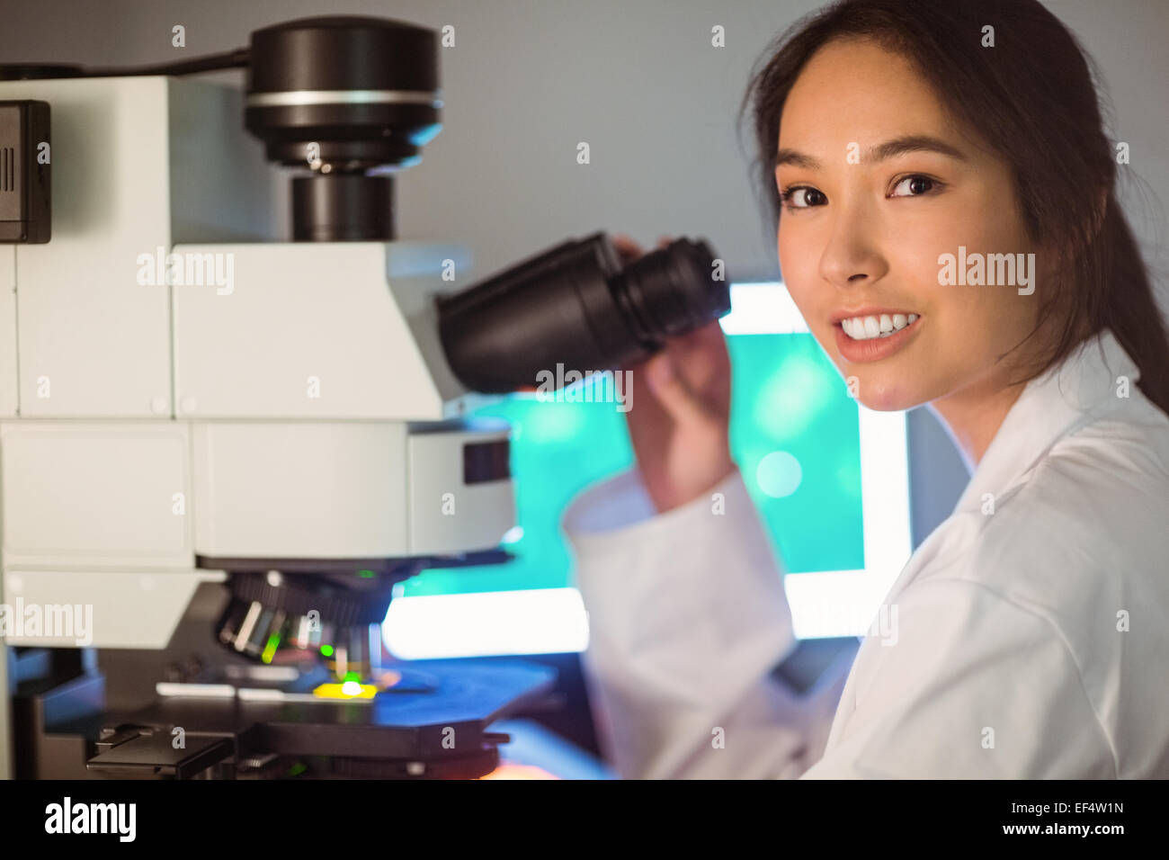 Science student looking through microscope Stock Photo - Alamy