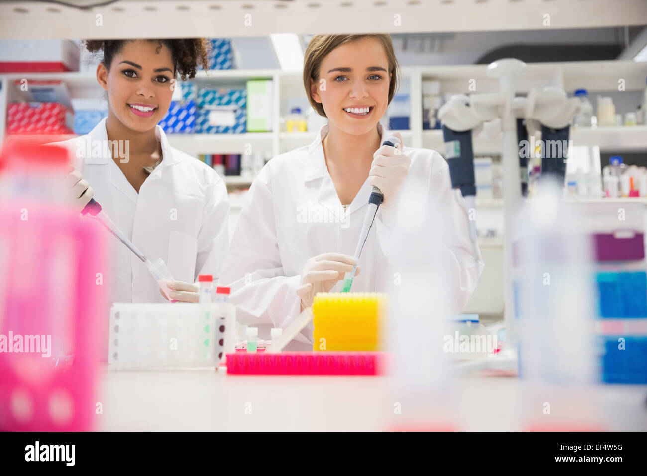Pretty science students using pipette Stock Photo - Alamy