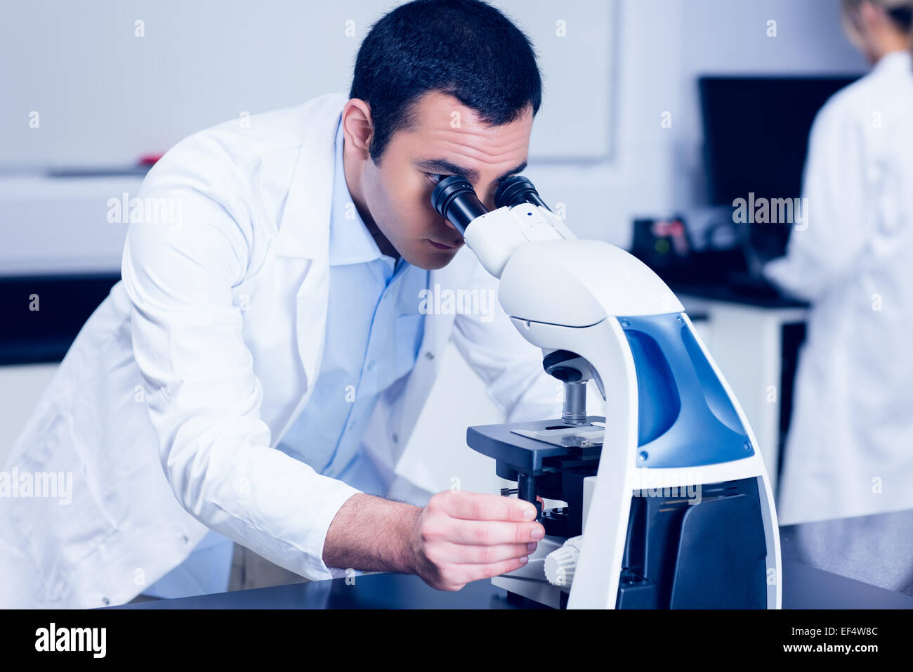 Science student looking through microscope Stock Photo - Alamy