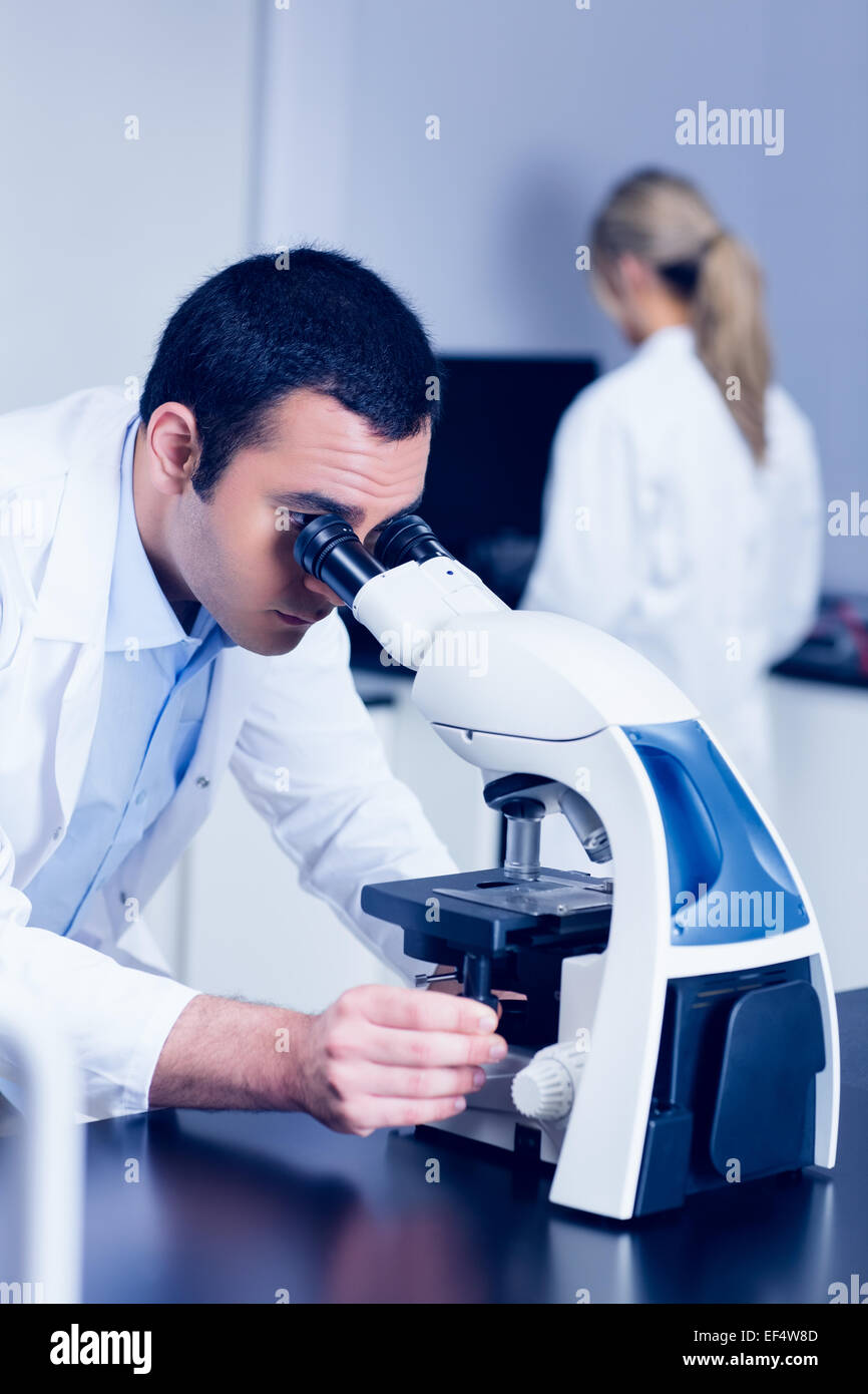 Science student looking through microscope in the lab Stock Photo - Alamy