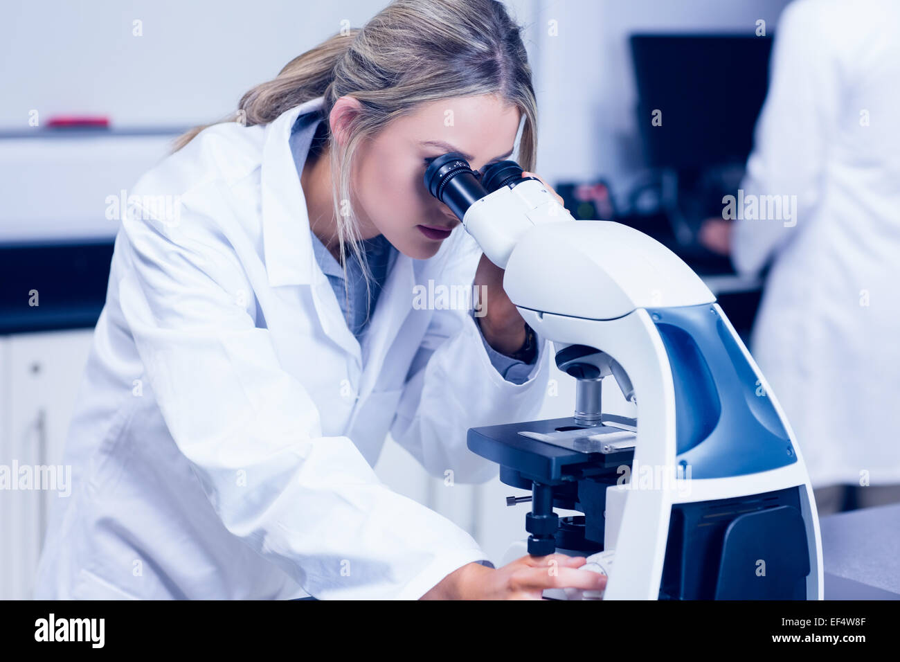 Science student looking through microscope in the lab Stock Photo - Alamy