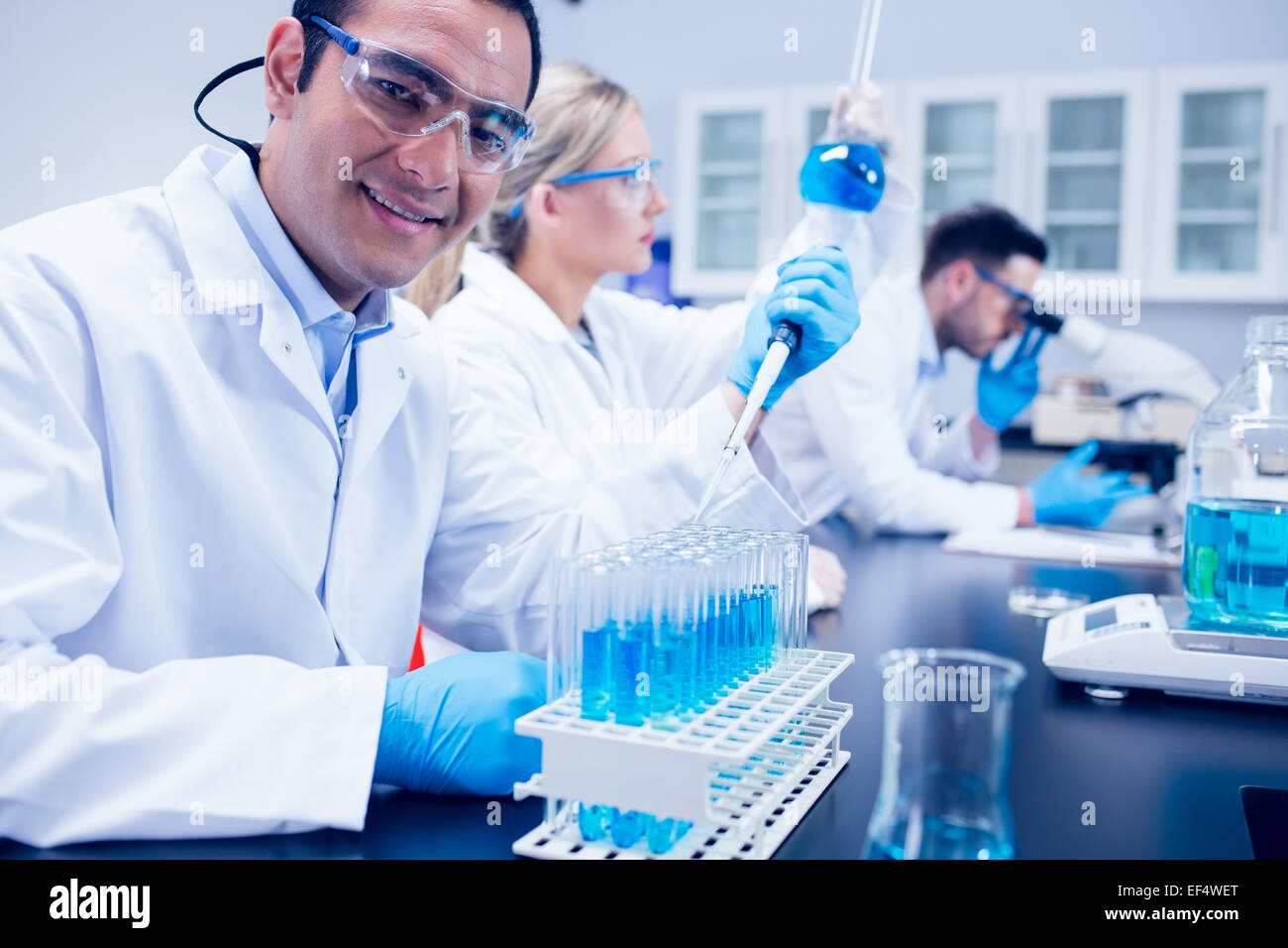 Science student using pipette in the lab to fill test tubes Stock Photo ...