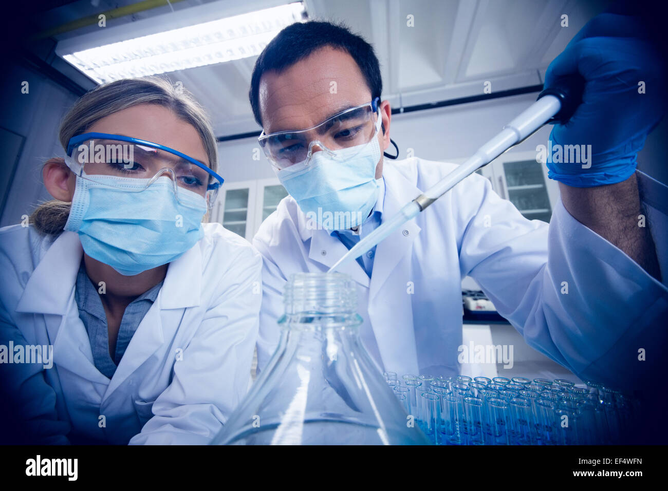 Science students using pipette to fill beaker Stock Photo - Alamy