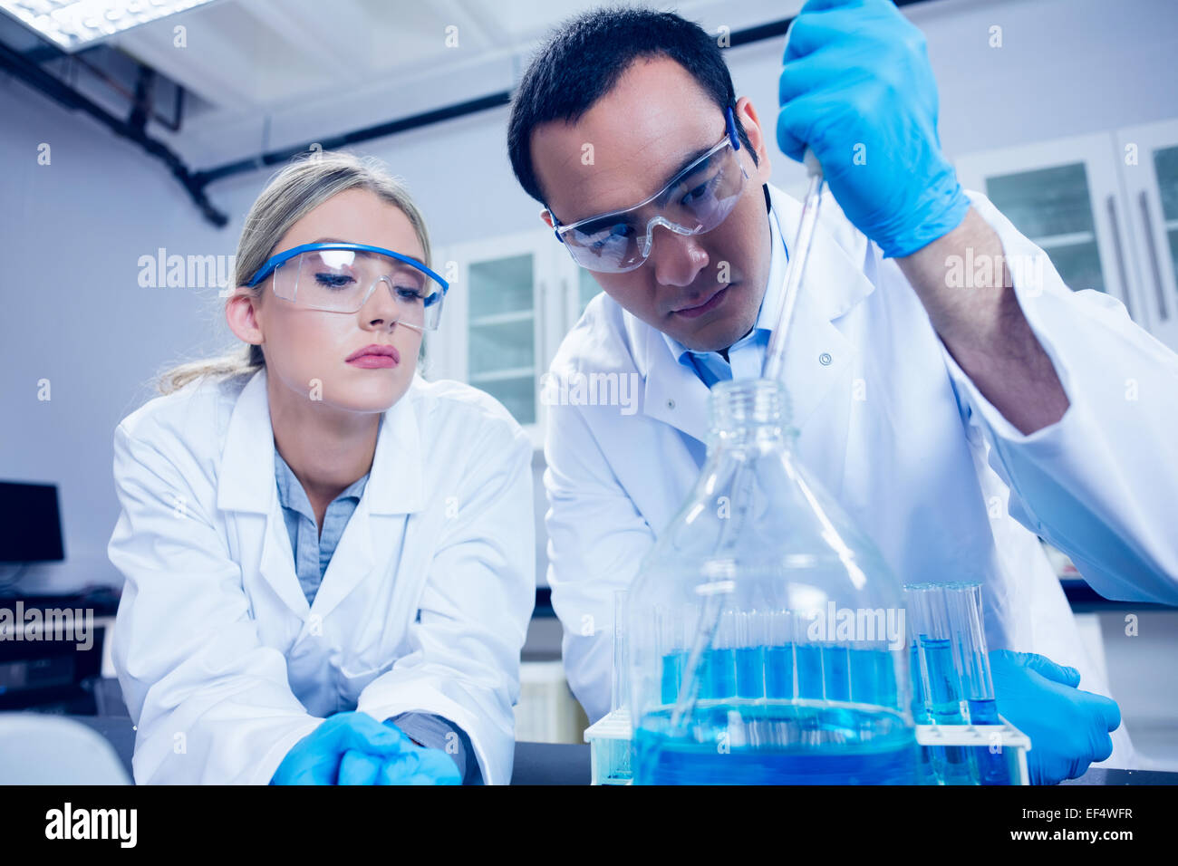Science students using pipette to fill beaker Stock Photo - Alamy