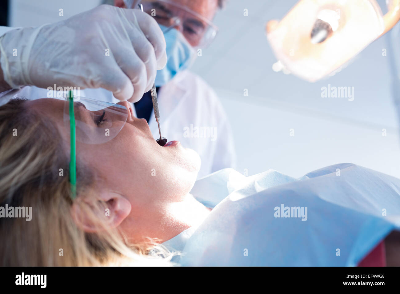 Dentist examining a patients teeth under bright light Stock Photo - Alamy