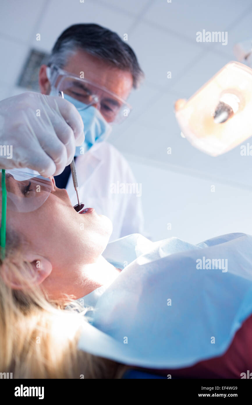Dentist examining a patients teeth under bright light Stock Photo - Alamy