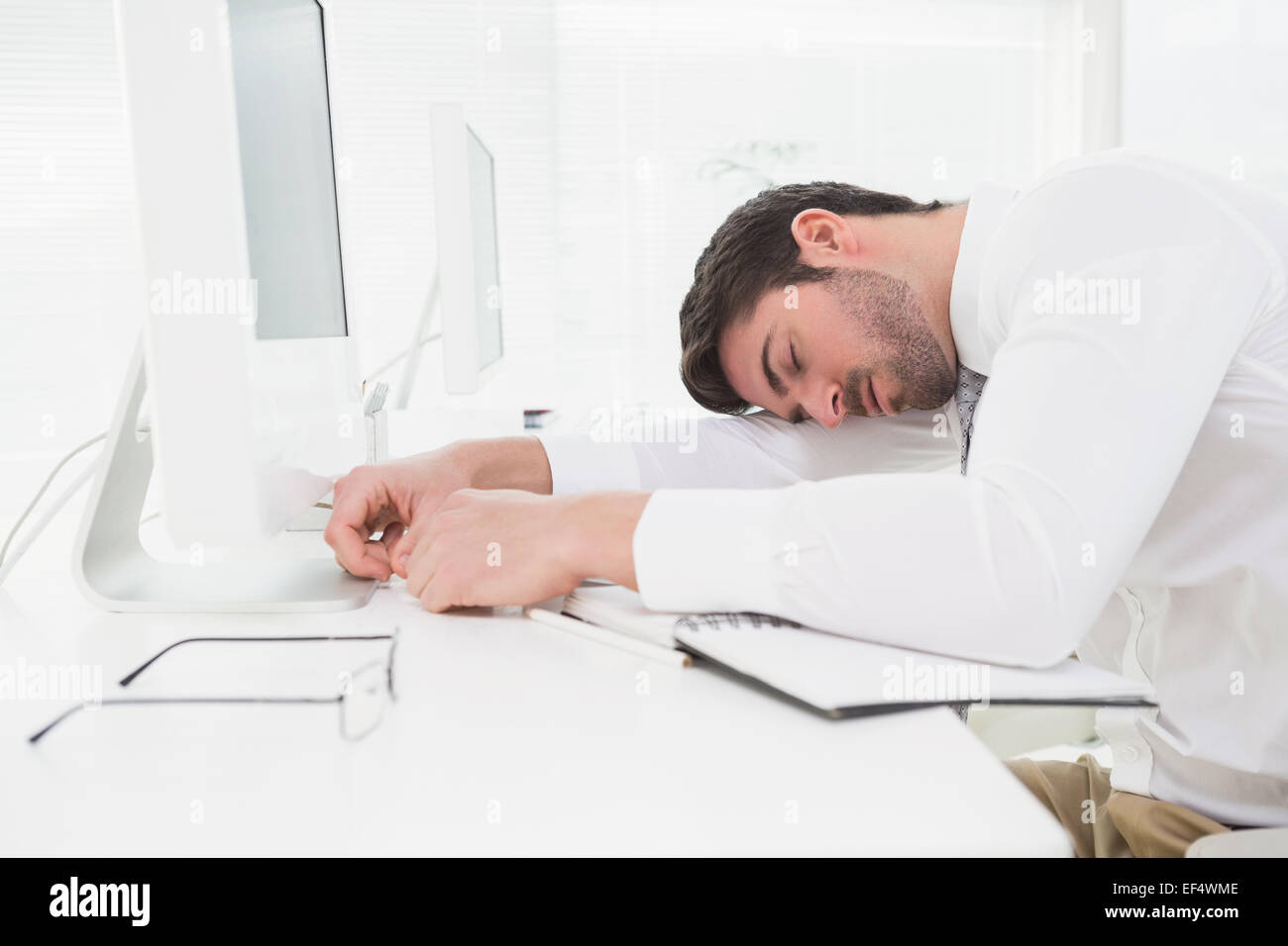 Tired businessman sleeping on keyboard Stock Photo - Alamy