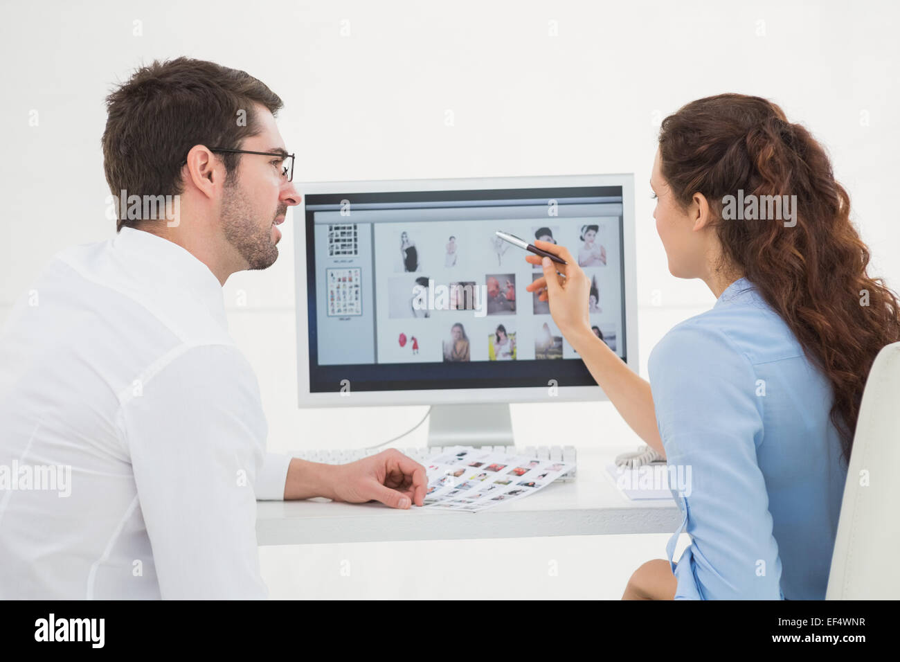 Teamwork speaking and working together on computer Stock Photo - Alamy