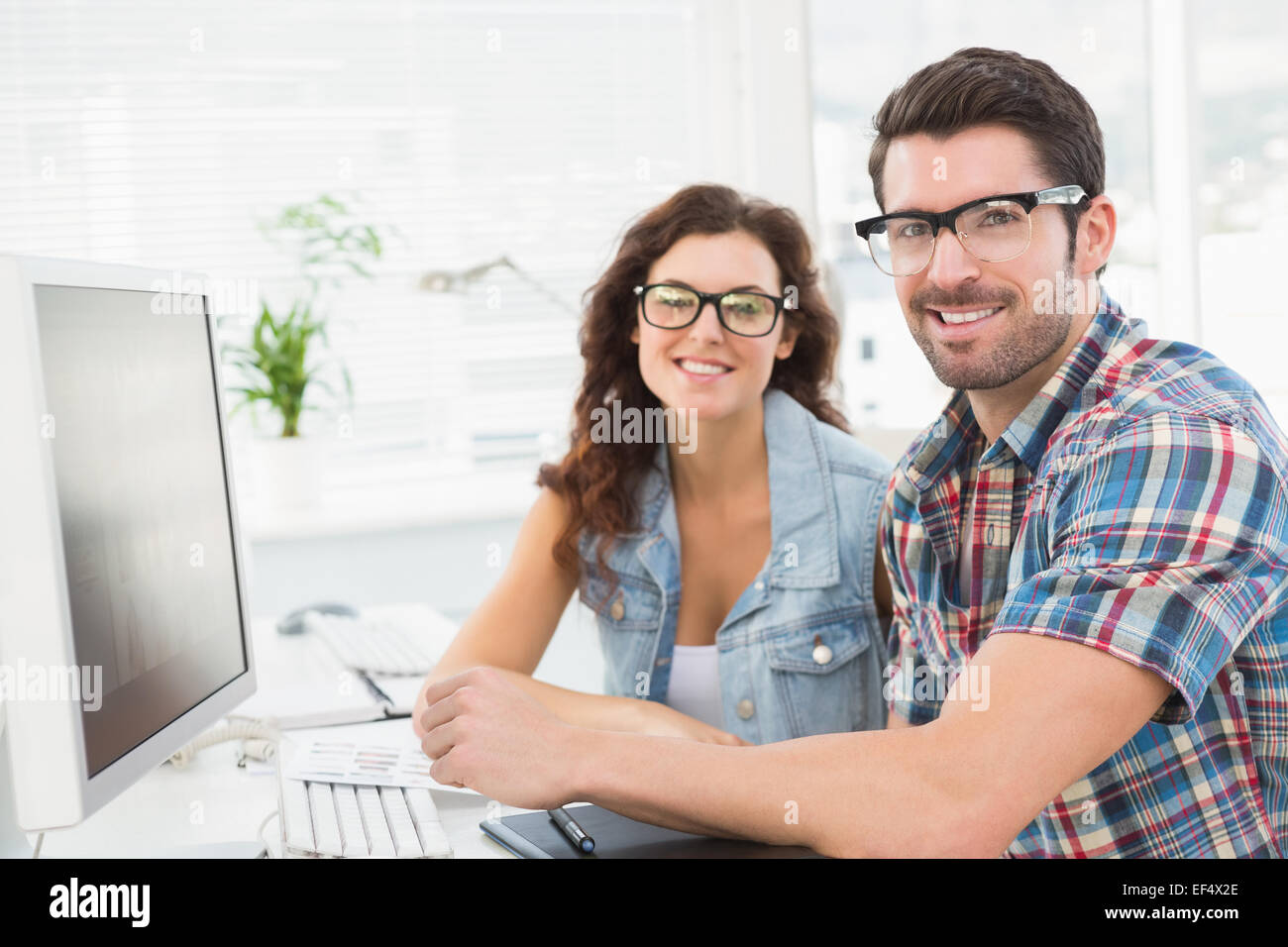 Portrait of smiling colleagues working together Stock Photo - Alamy