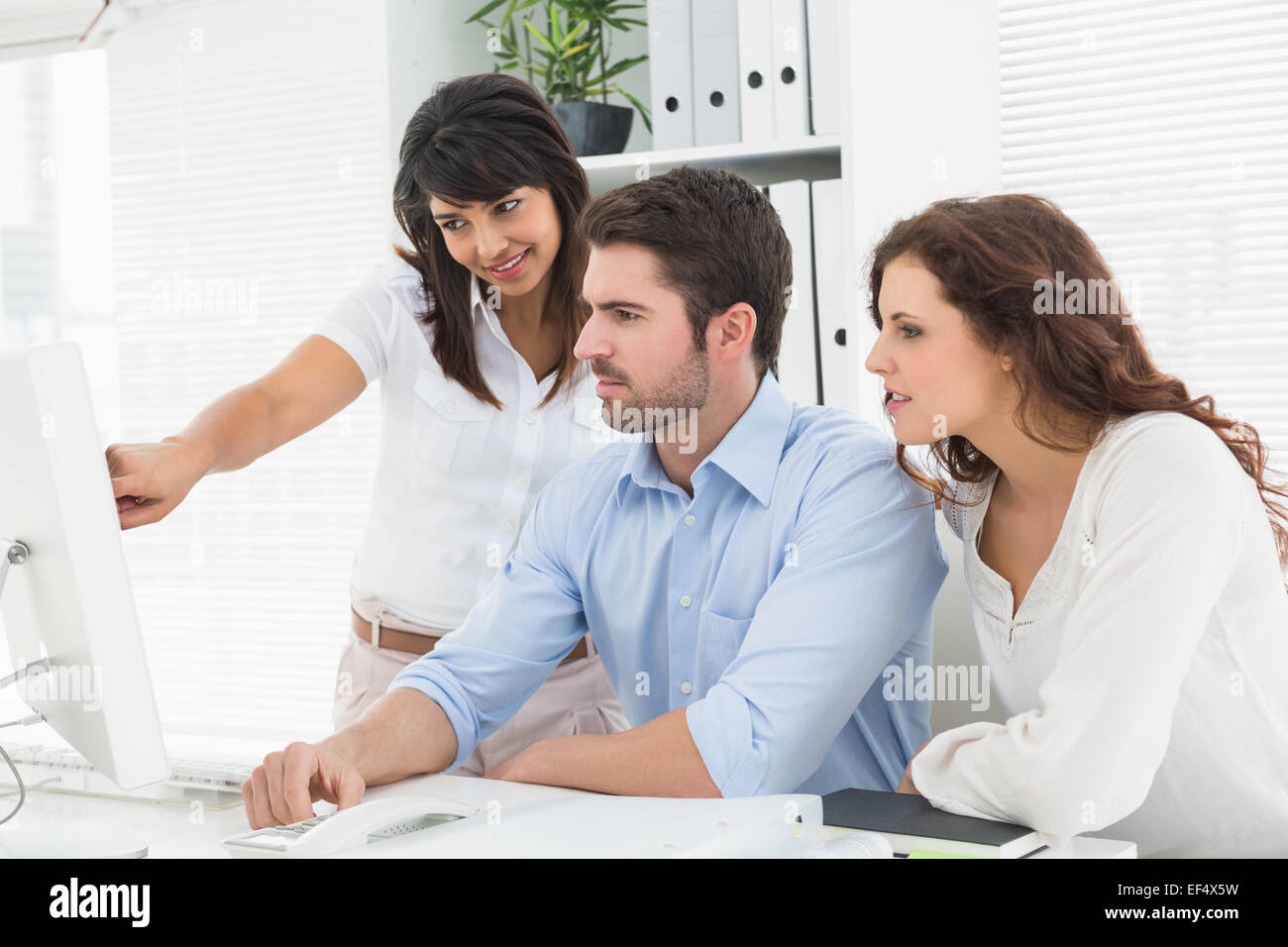 Concentrated teamwork using computer monitor Stock Photo - Alamy