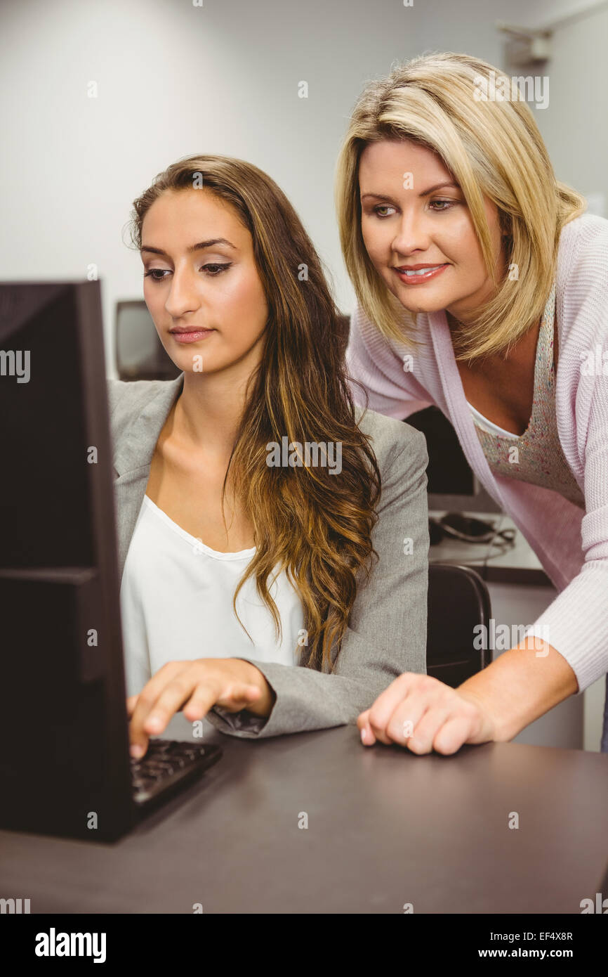 Smiling teacher and student behind desk at computer Stock Photo - Alamy