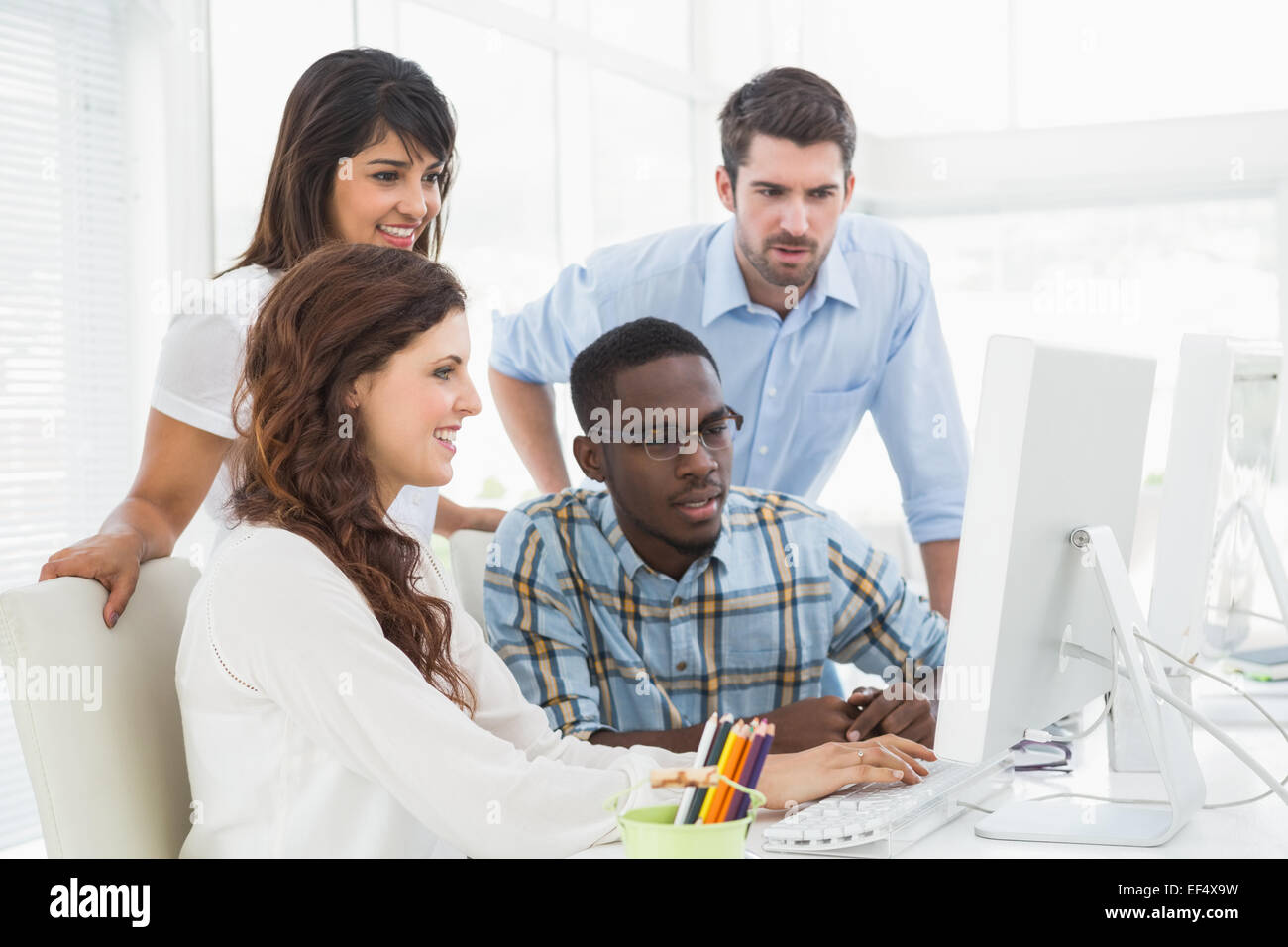 Concentrated coworkers using computer together Stock Photo - Alamy