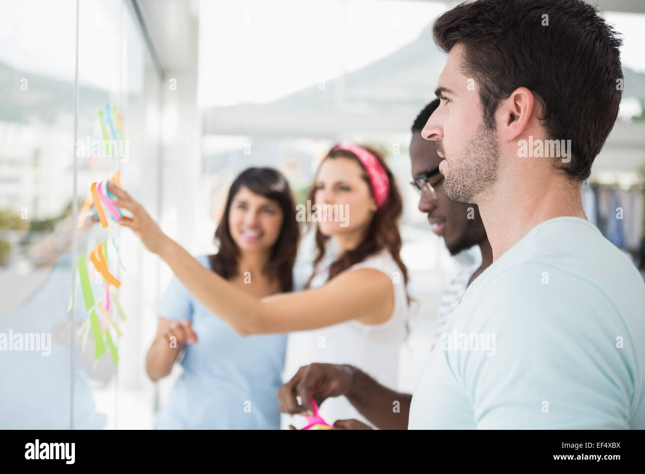 Smiling teamwork reading sticky notes Stock Photo - Alamy