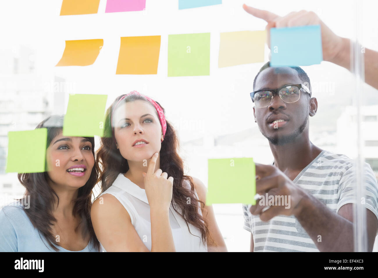 Focused teamwork reading sticky notes Stock Photo - Alamy
