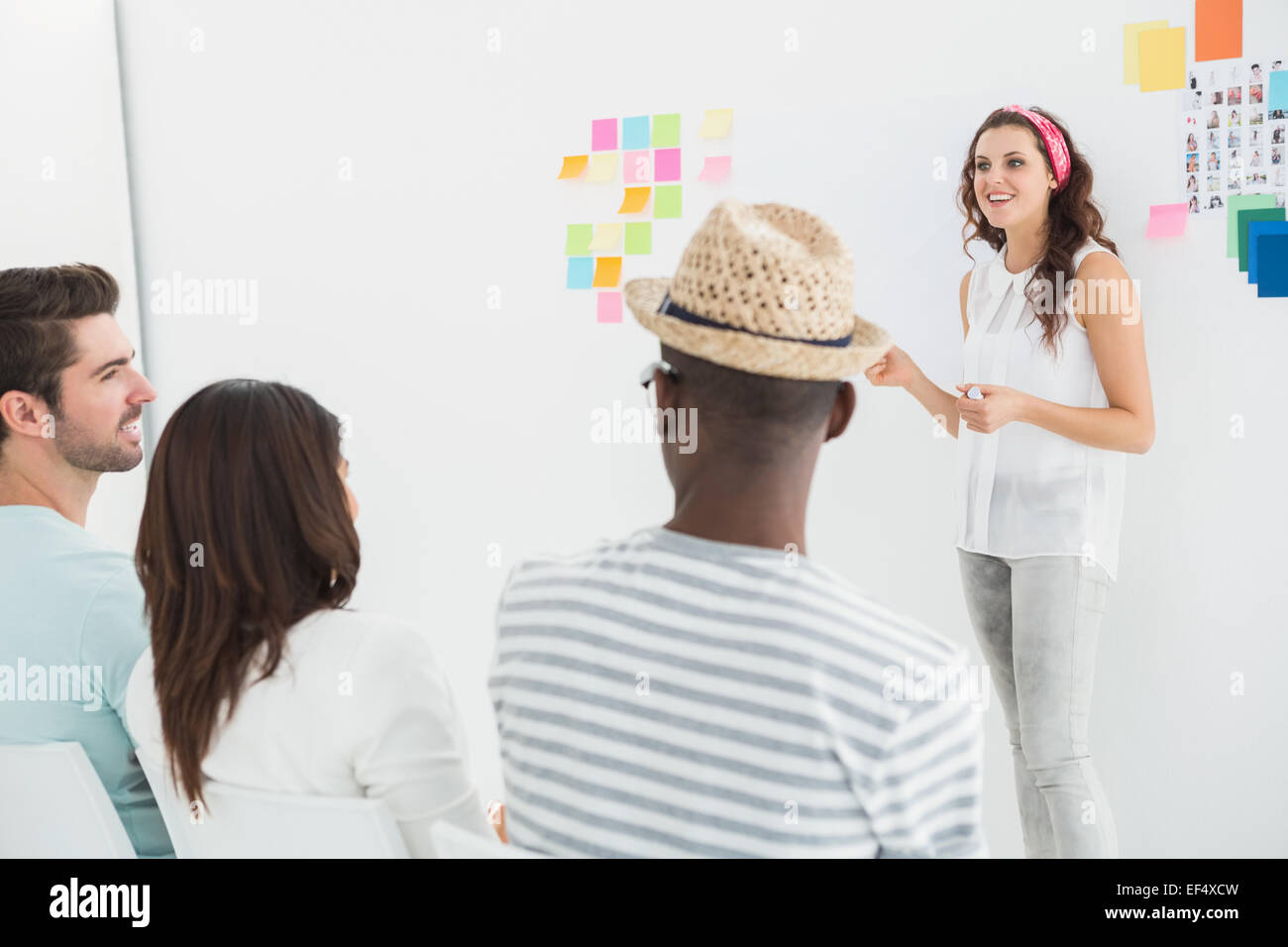 Businesswoman giving presenting in front of group Stock Photo - Alamy