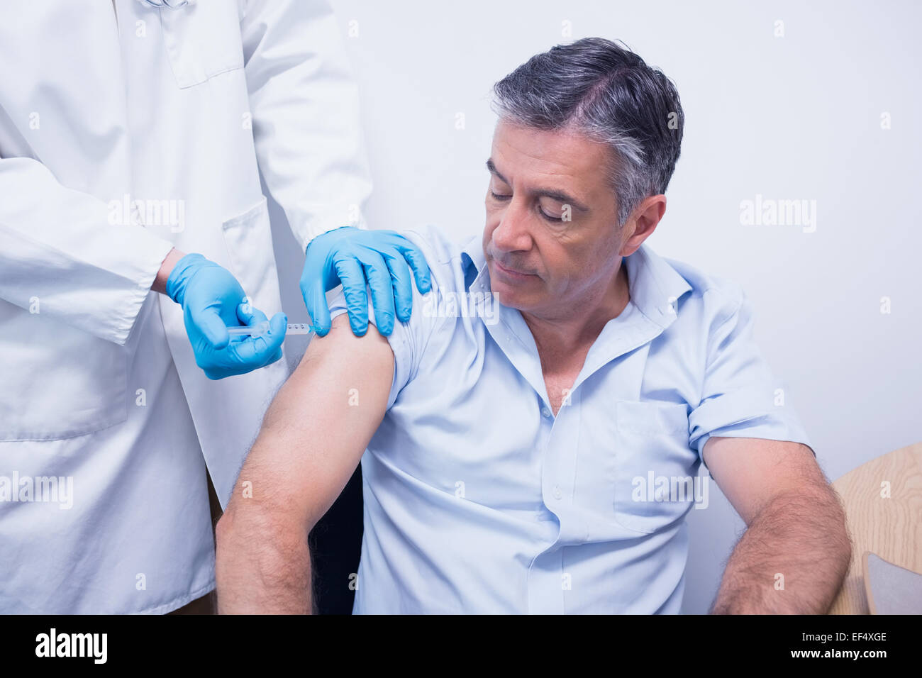 Doctor giving injection to his patient Stock Photo - Alamy