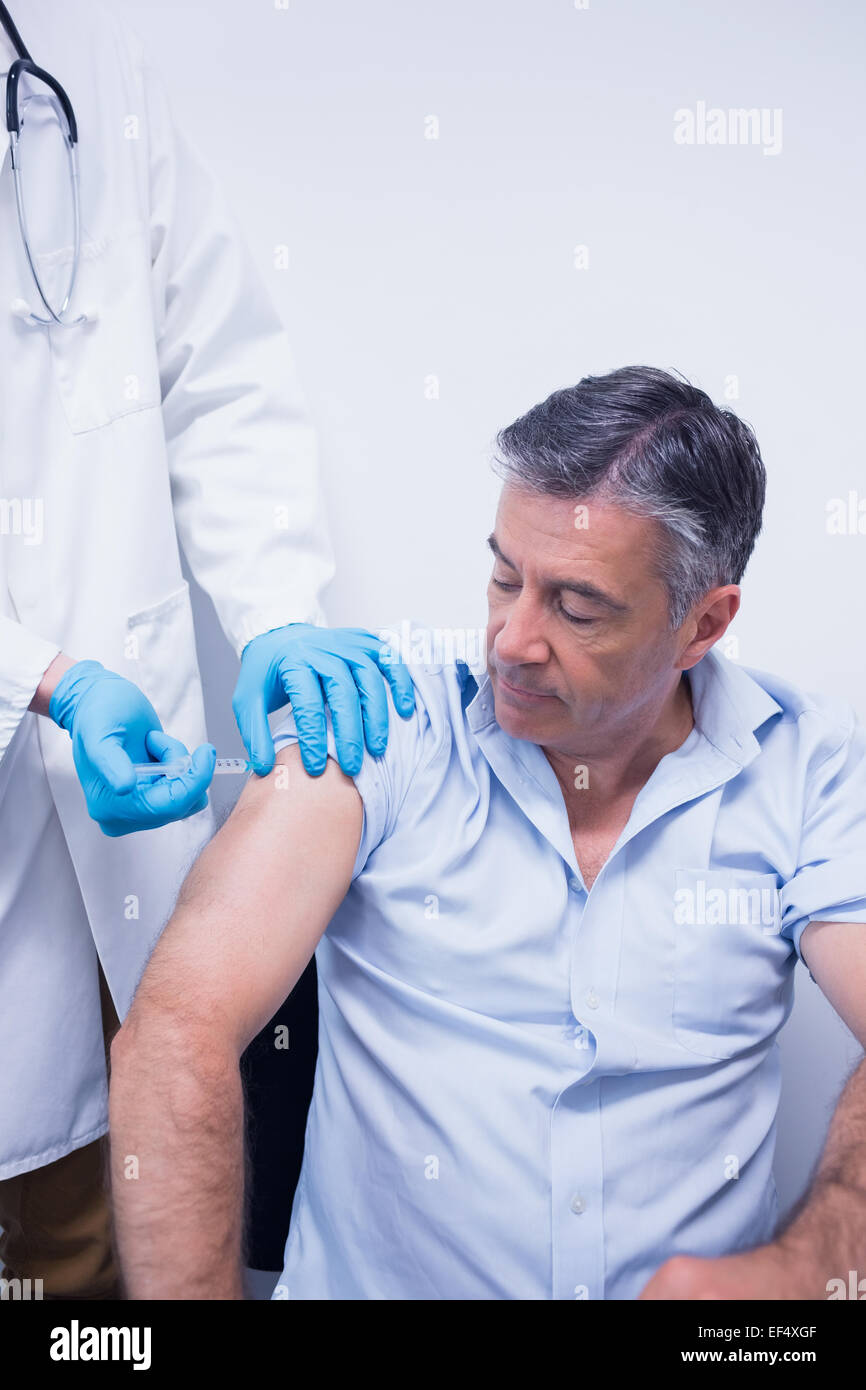 Doctor giving injection male patient hi-res stock photography and ...