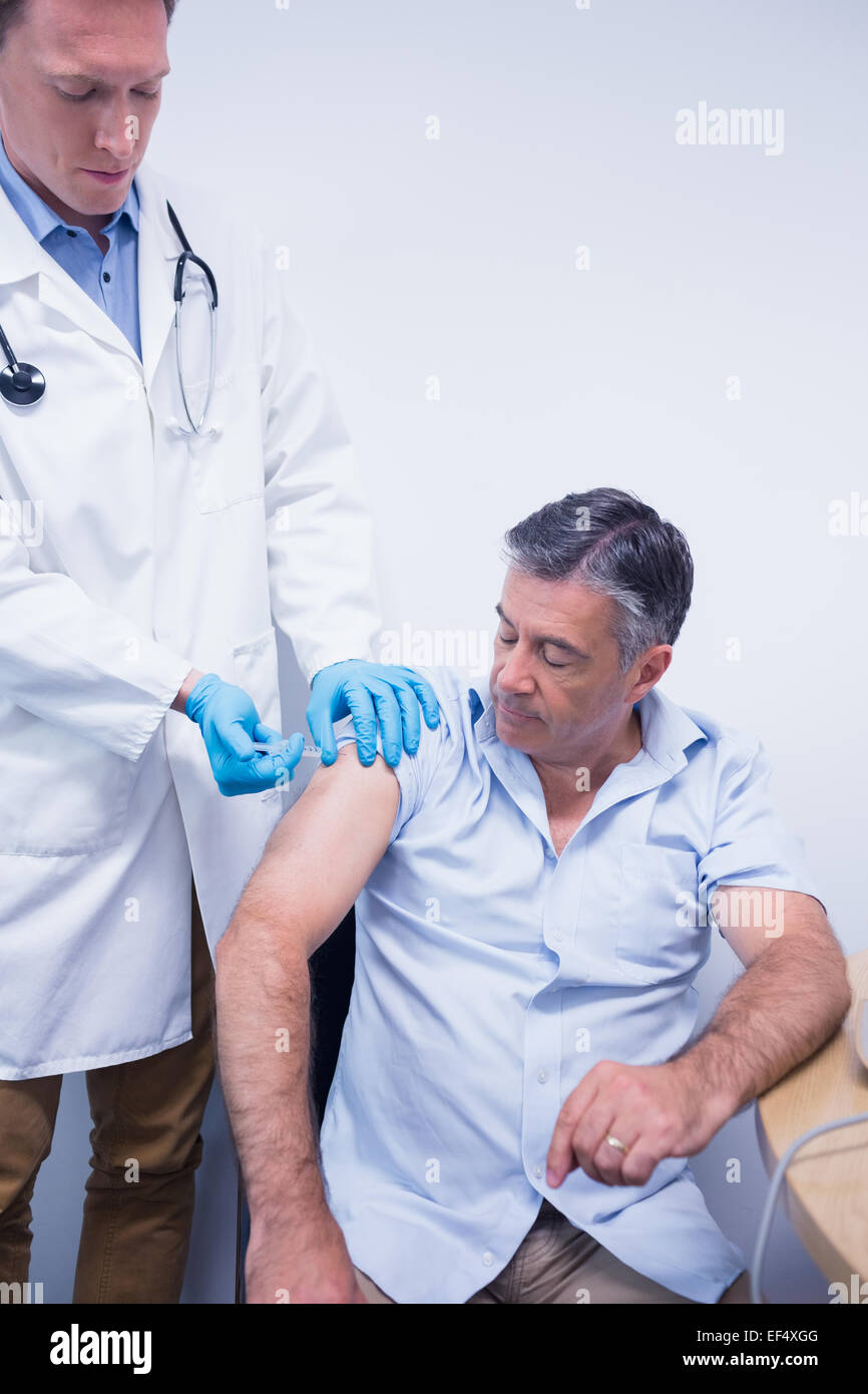 Doctor giving injection to his patient Stock Photo - Alamy