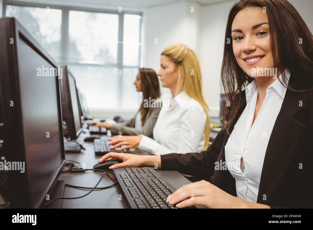 Happy woman in computer room smiling at camera Stock Photo - Alamy