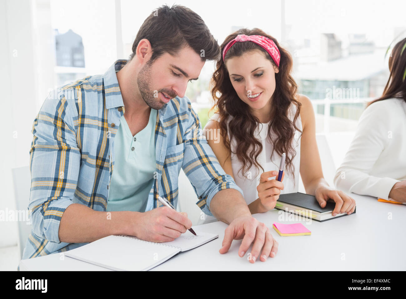 Cheerful teamwork sitting and working together Stock Photo - Alamy