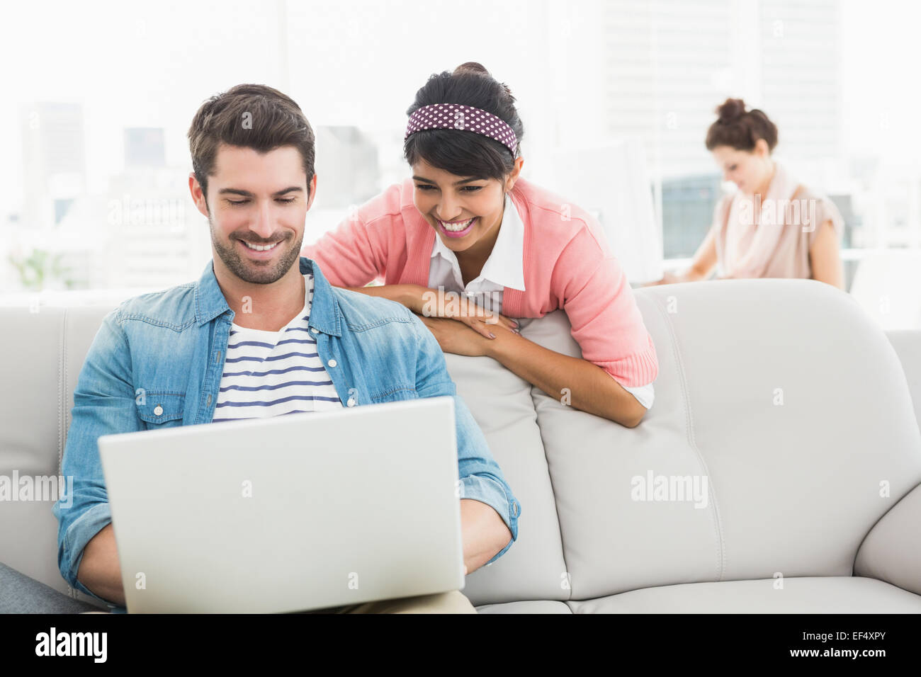 Happy teamwork working together with laptop Stock Photo - Alamy